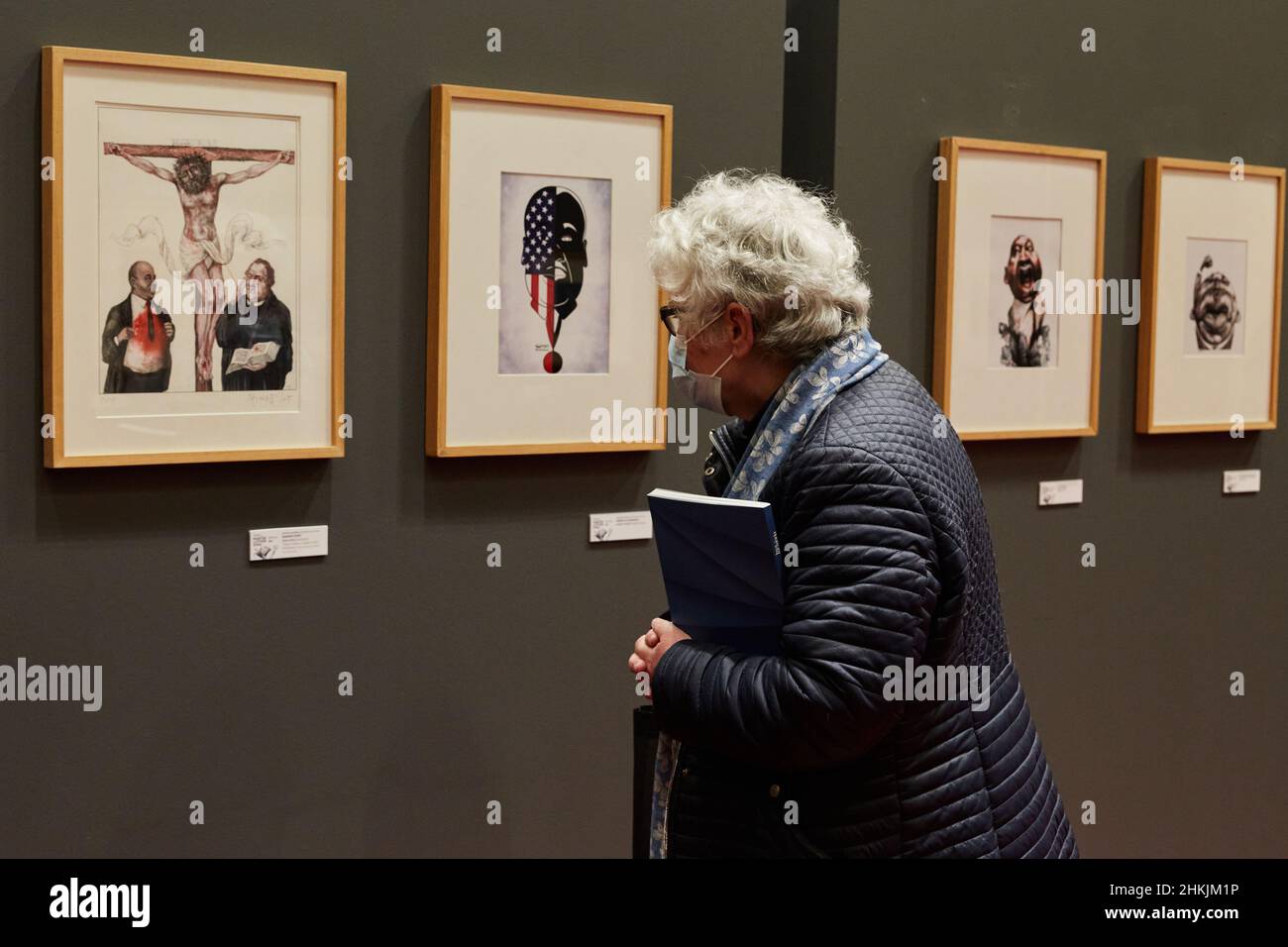 Visitor to the Caricature exhibition looks at the artworks during the ...