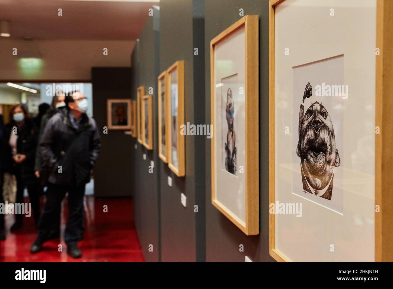 Visitors to the Caricature exhibition look at the artworks during the ...