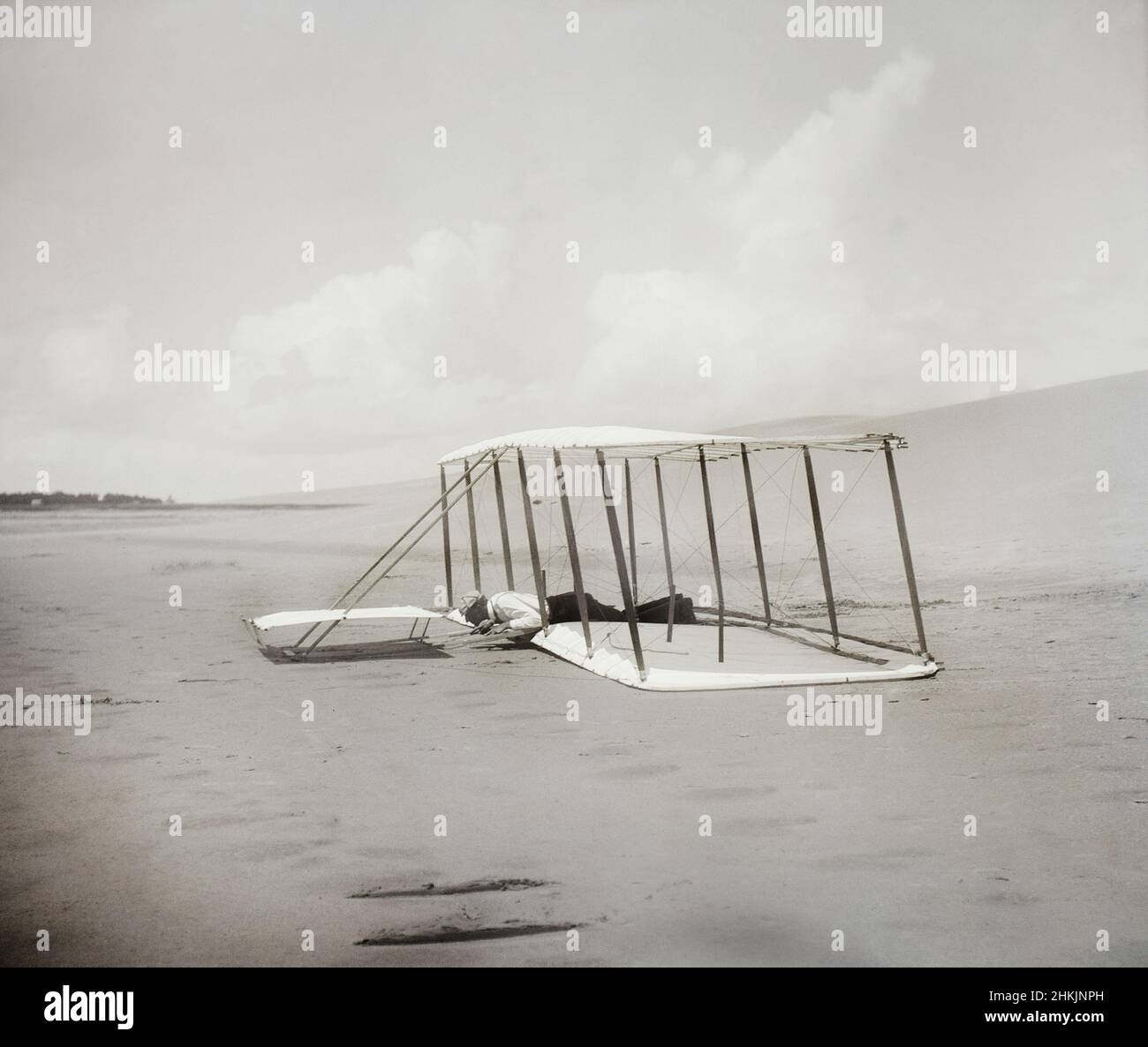 Wilbur Wright in prone position on glider just after landing, Kitty ...