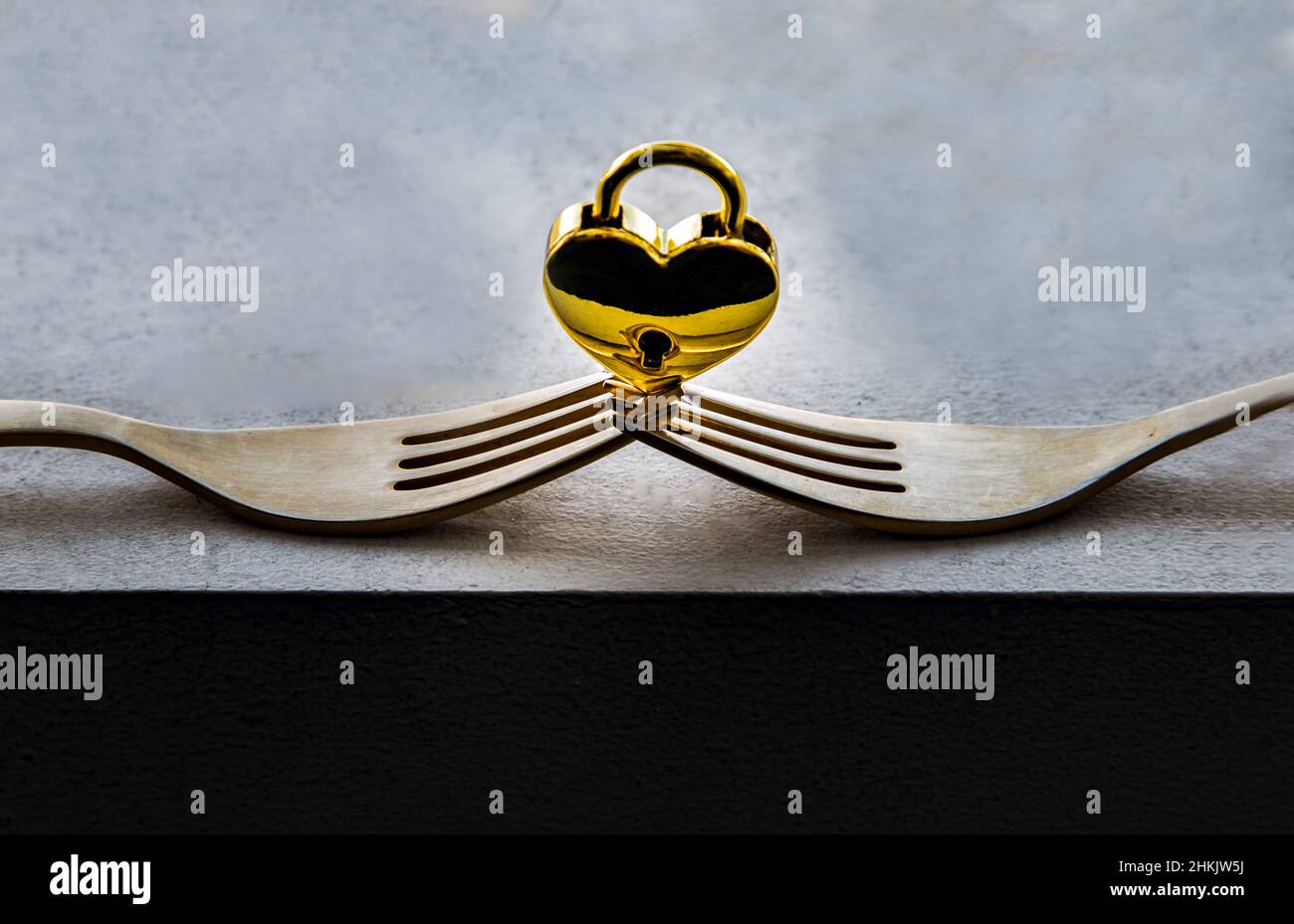 Golden heart shaped love padlock balanced on a composition of two ...