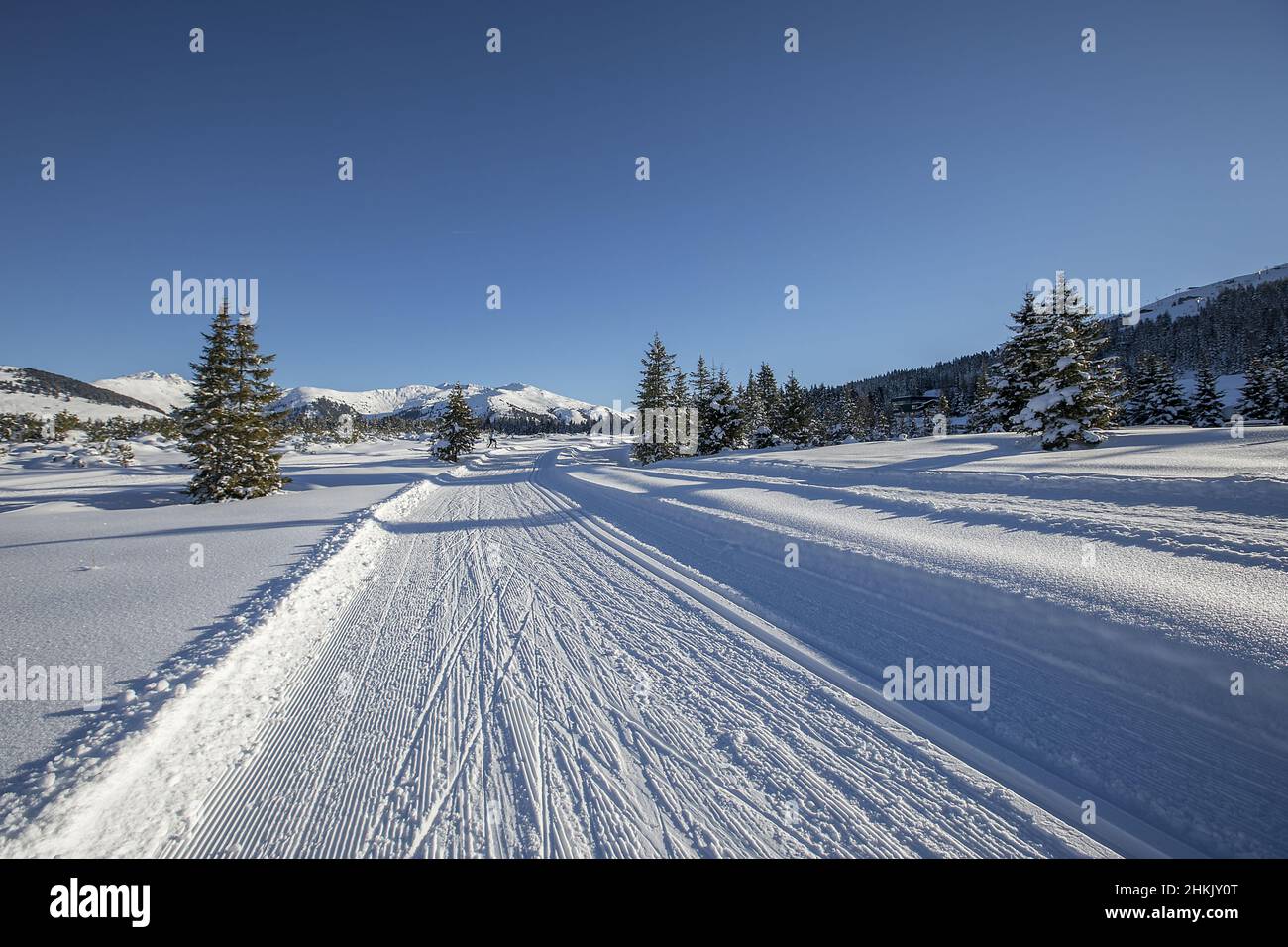 Long snowy trail through a rural area leading to mountains Stock Photo ...