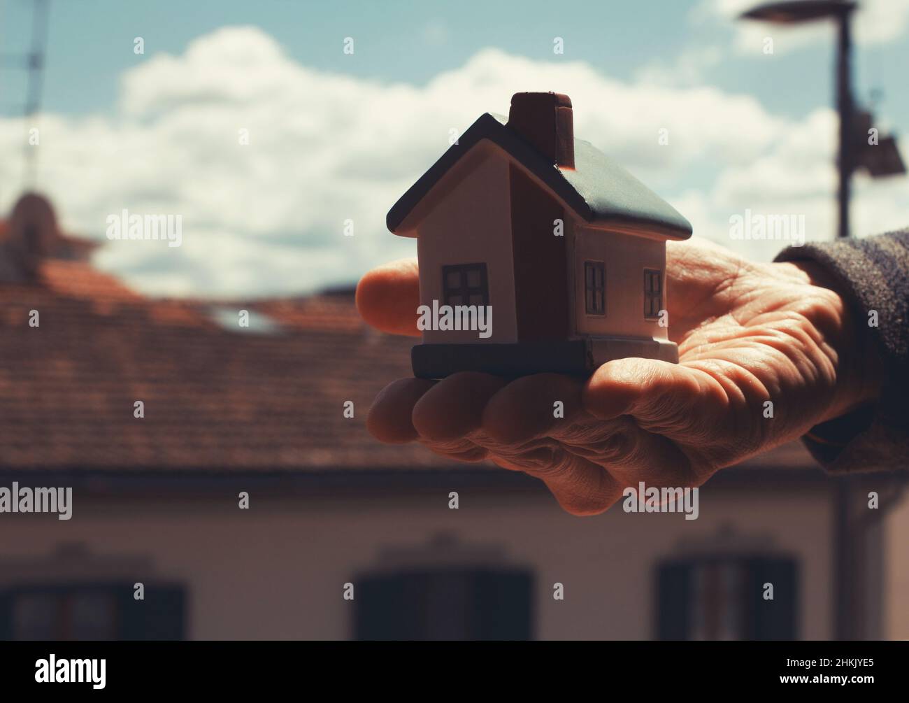 Italian real agent man holding a small house with a classic Italian ...