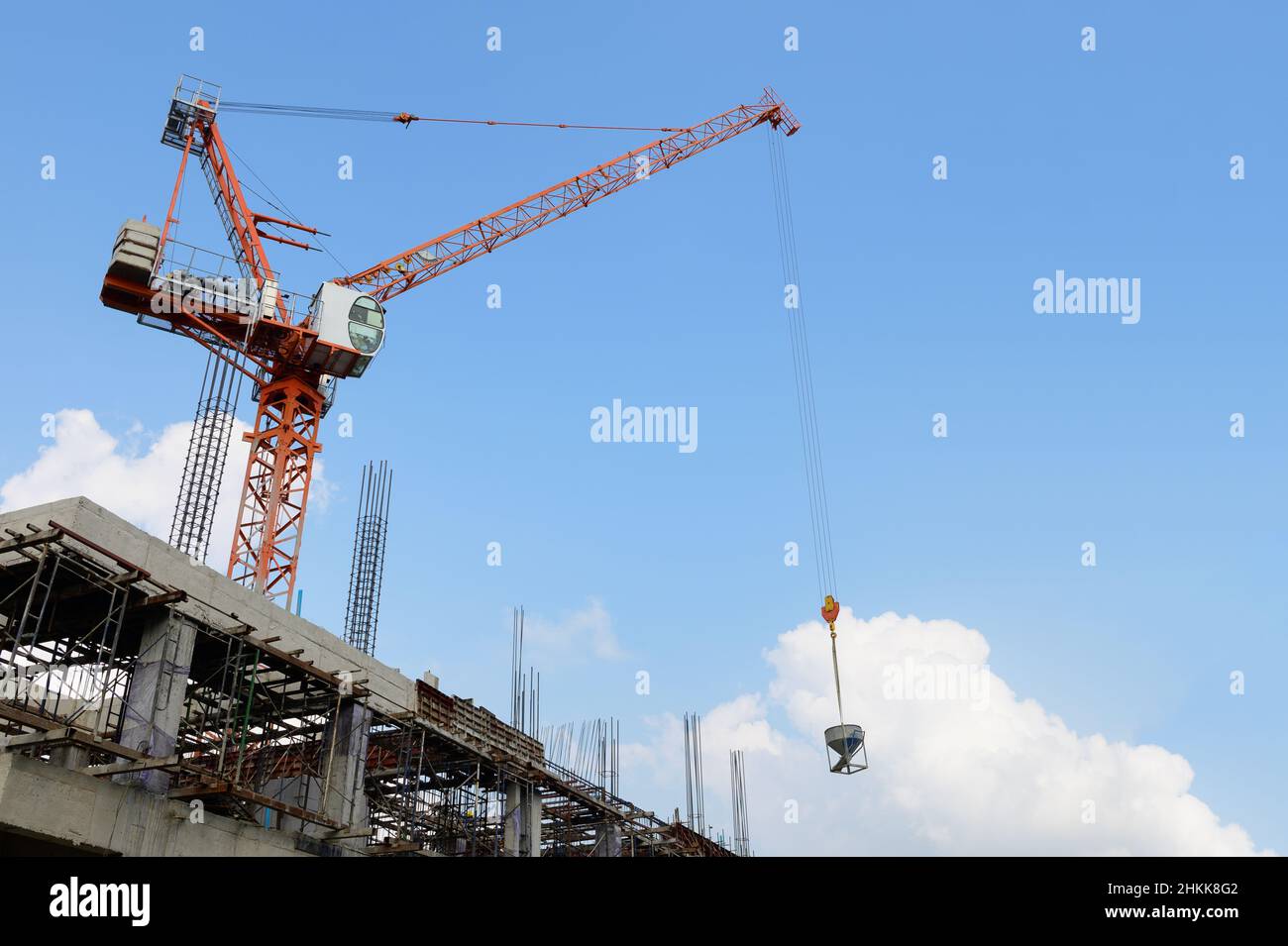Crane lifting concrete bucket on construction site Stock Photo - Alamy