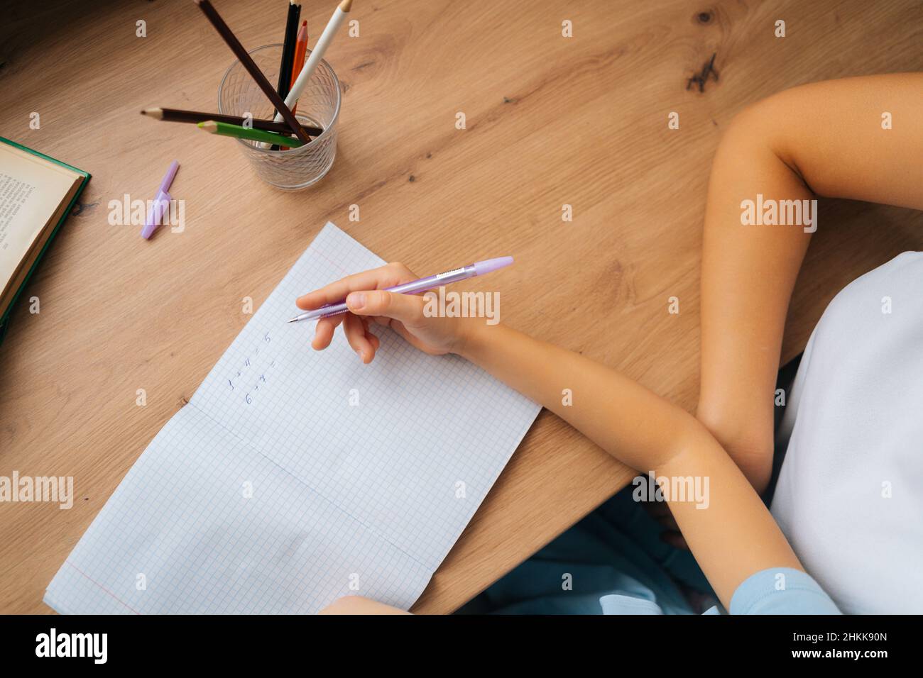 Close-up high-angle view of primary daughter doing homework writing in ...