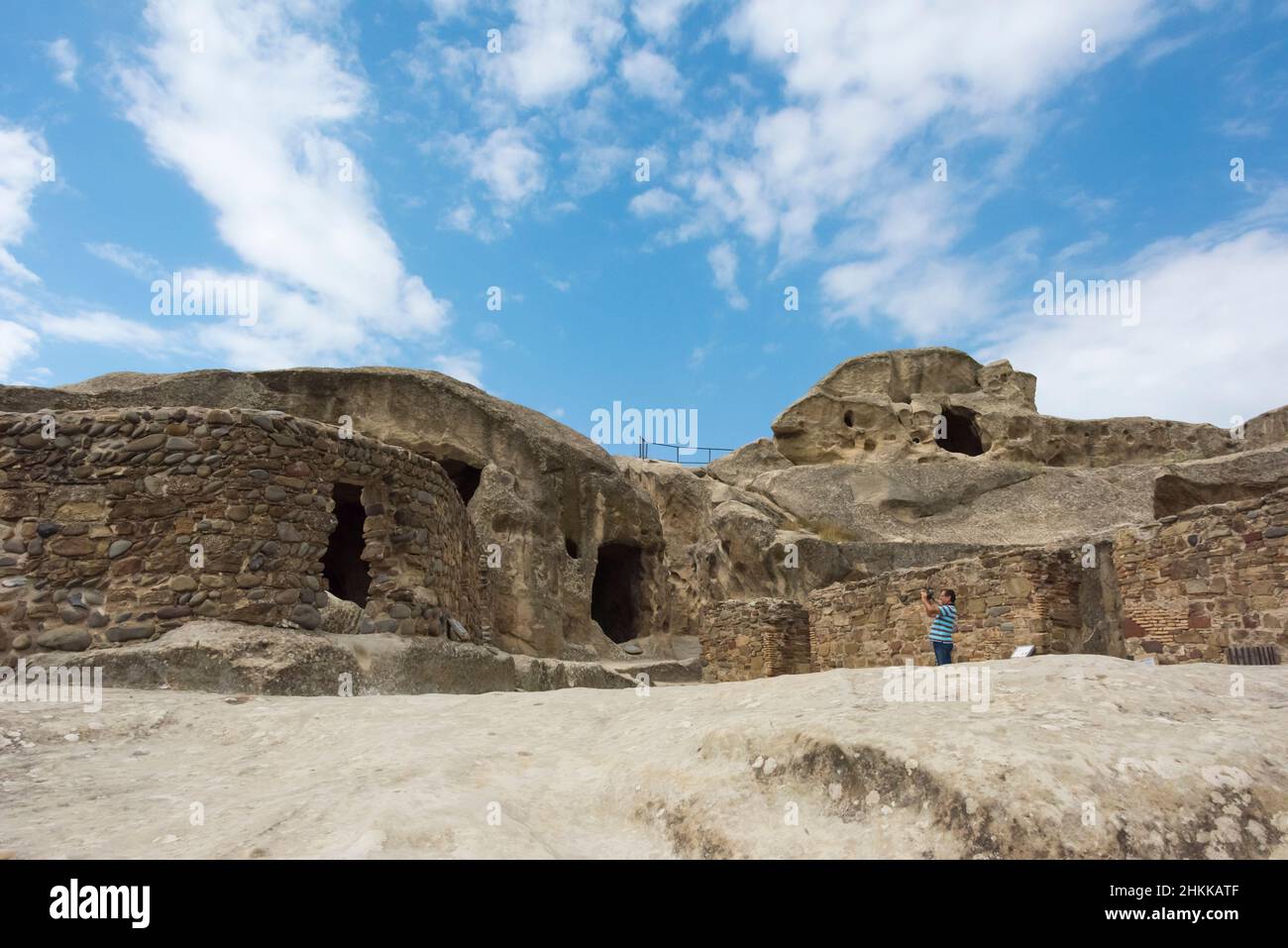 Tourists at Uplistsikhe cave complex, monument of rock architecture ...