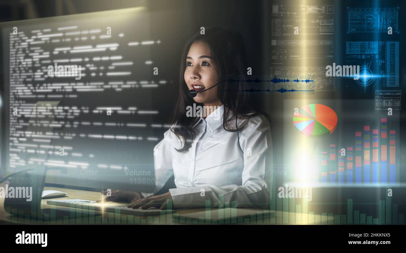 Asian Woman support desk working hard late at night over visual screen ...