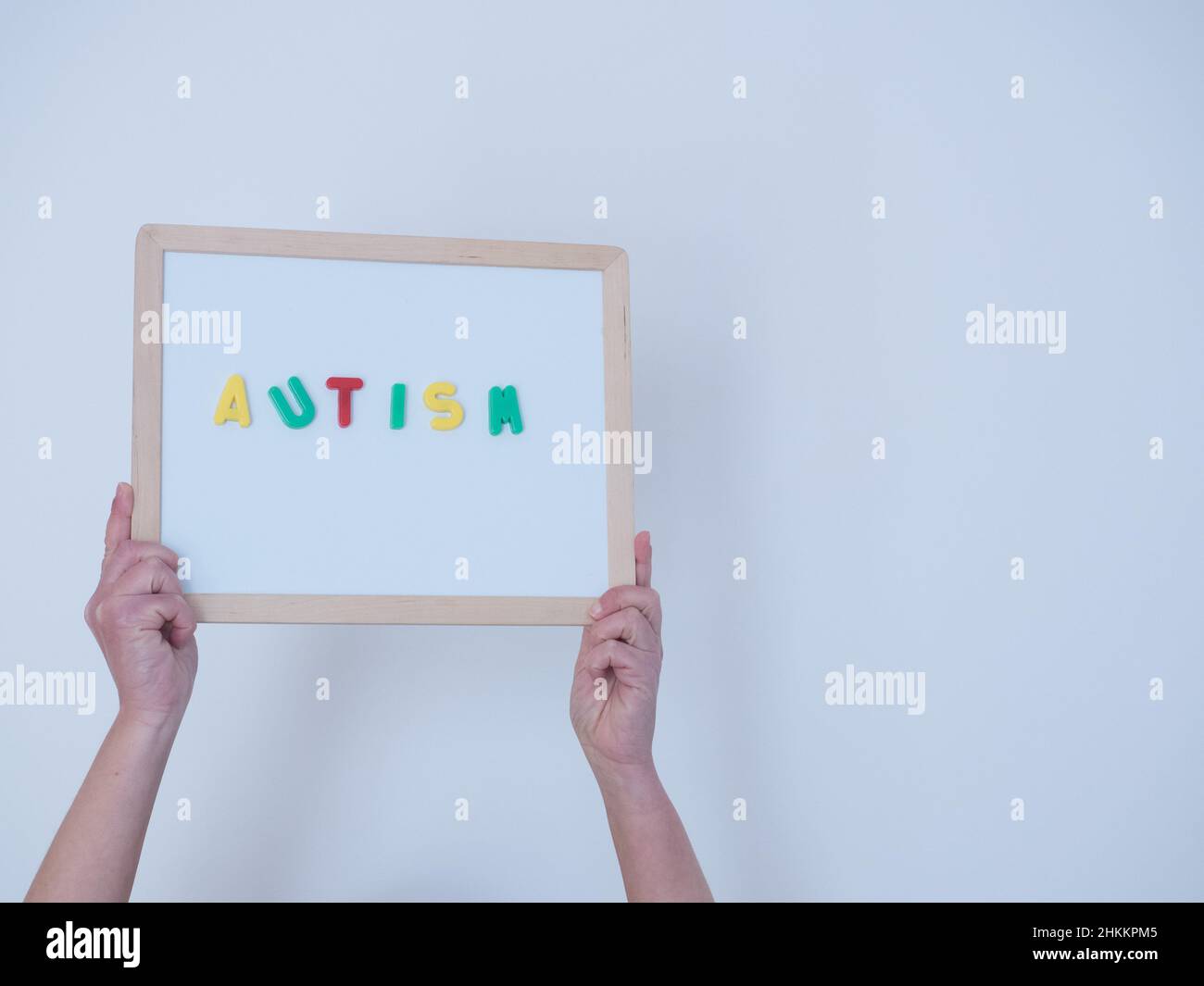 word autism with colored magnetic letters on white board. health ...