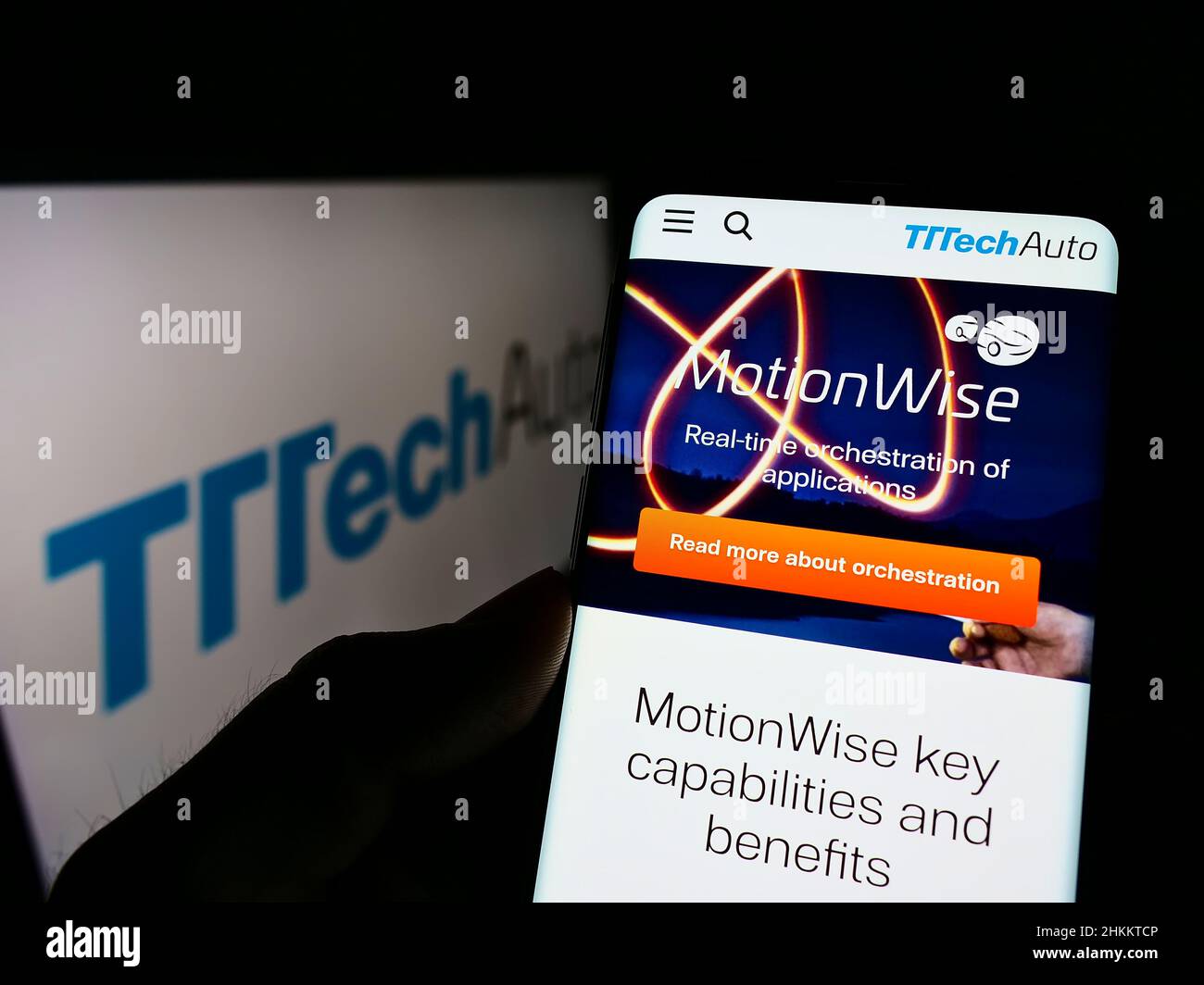 Person holding cellphone with website of autonomous driving company ...