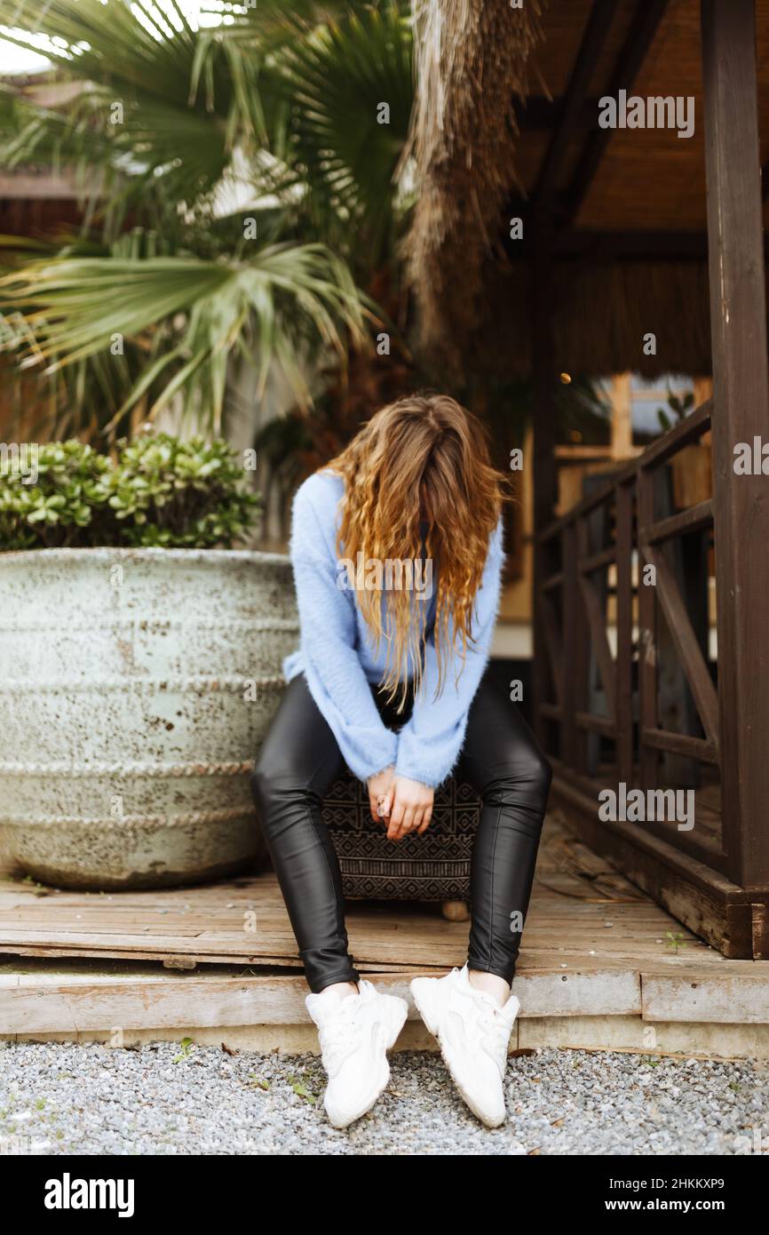 Woman sitting out in garden, face down,depression concept, deep in ...