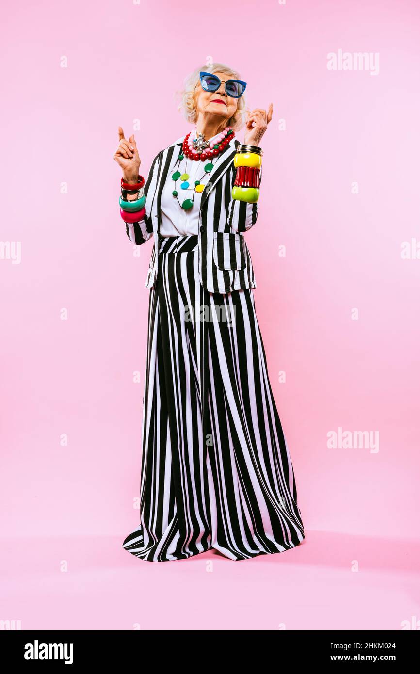 Happy and funny cool old lady with fashionable clothes portrait on ...