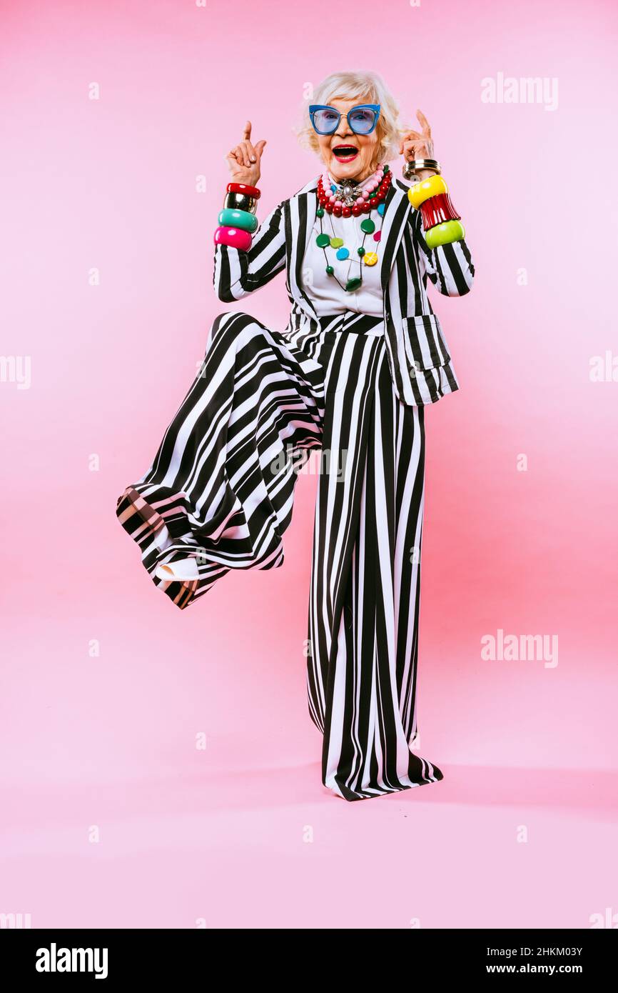 Happy and funny cool old lady with fashionable clothes portrait on ...