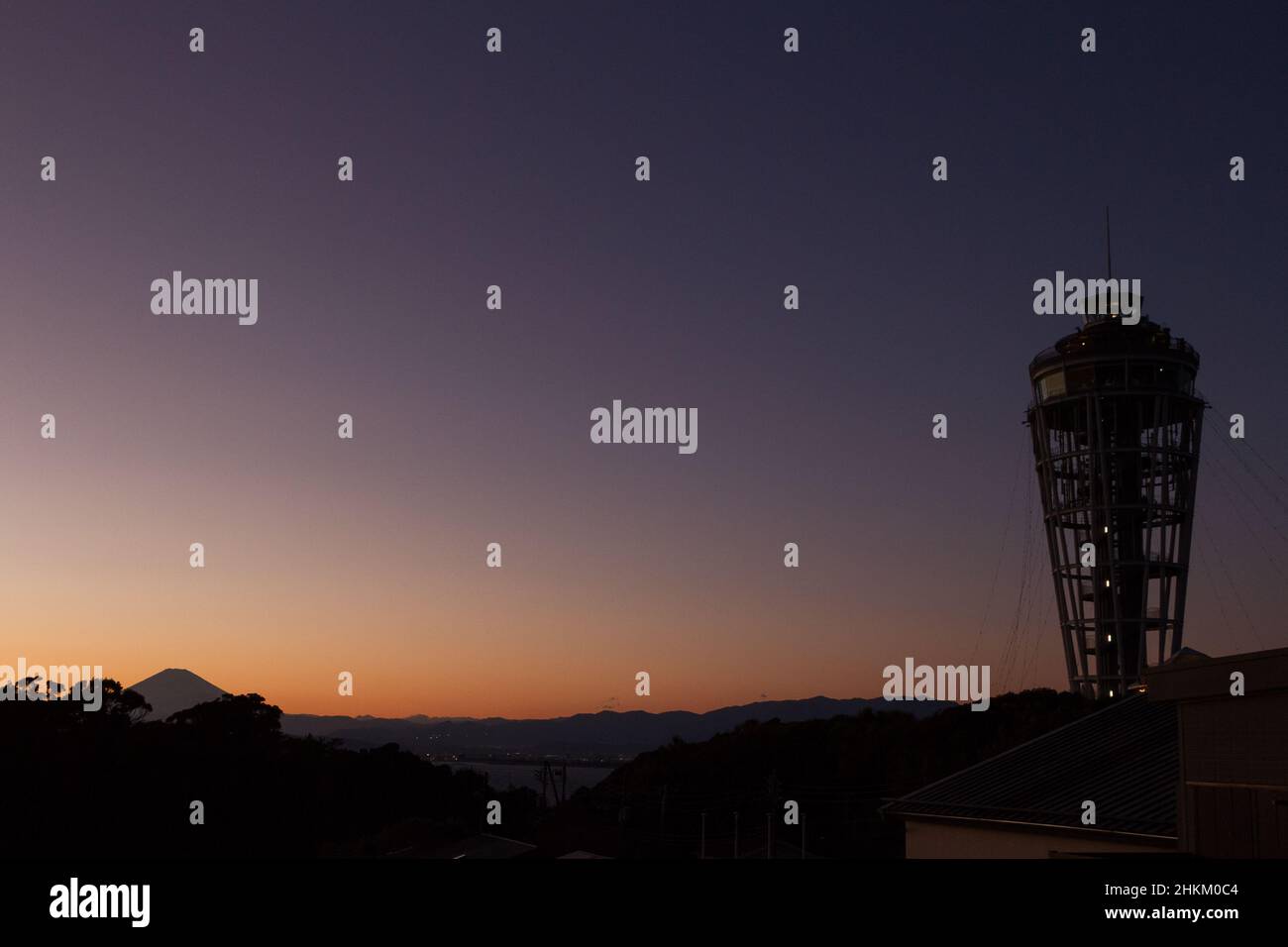 Enoshima lighthouse, known as the Sea Candle at sunset with Mount Fuji ...
