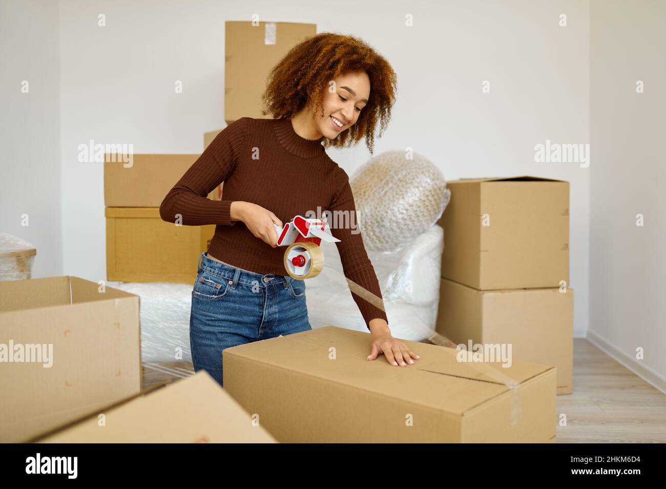 Woman packing box to new apartment move Stock Photo - Alamy