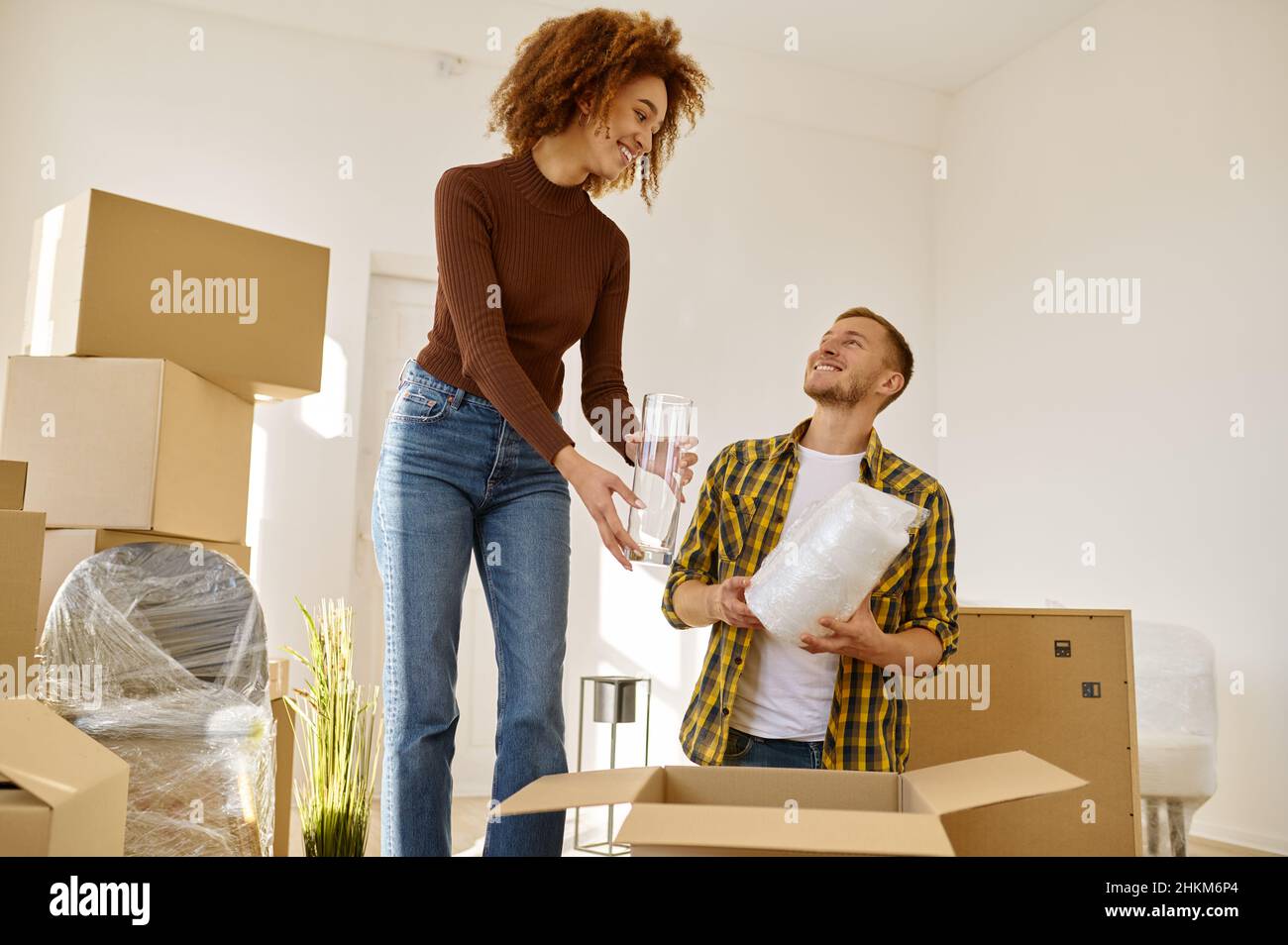 Couple packing stuff among plenty of boxes Stock Photo - Alamy
