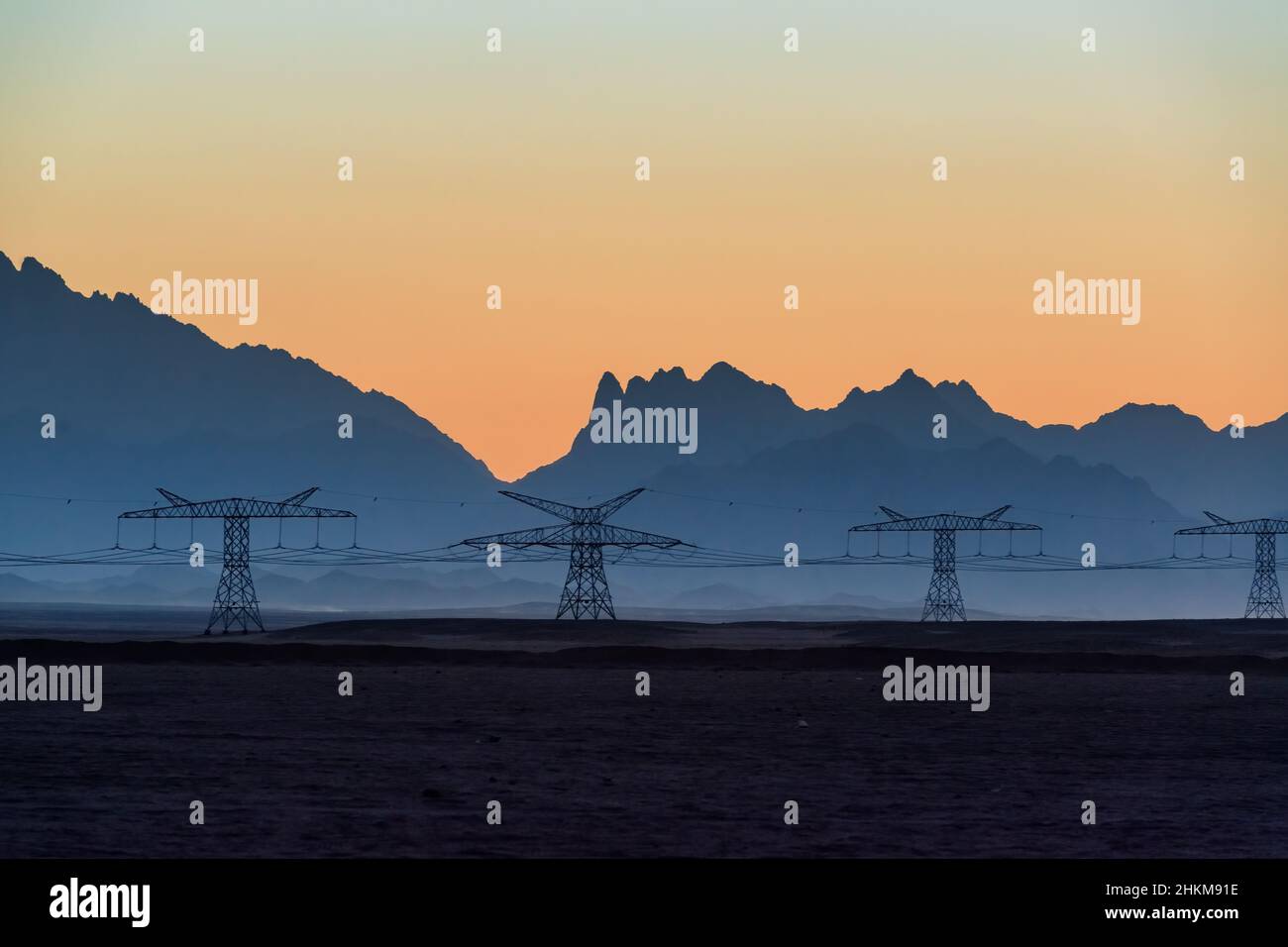 Big powerline in the desert against beautiful evening mountains ...