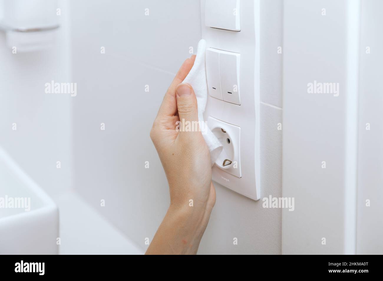 Cleaning switches and sockets with a microfiber cloth. Woman hand using ...