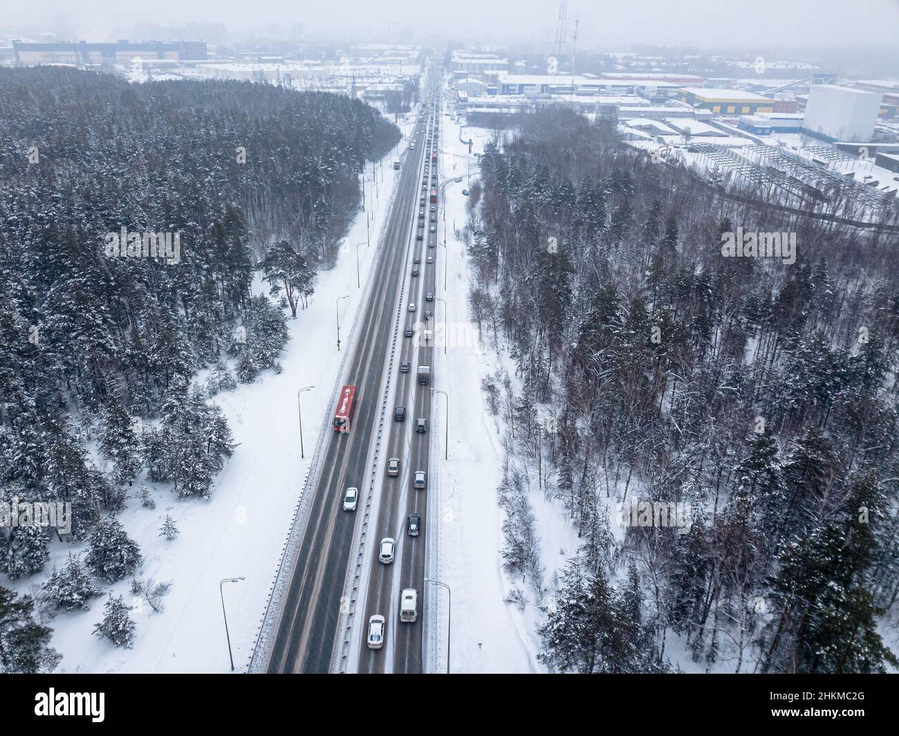 A highway in the middle of a winter forest. View from a height. Traffic ...
