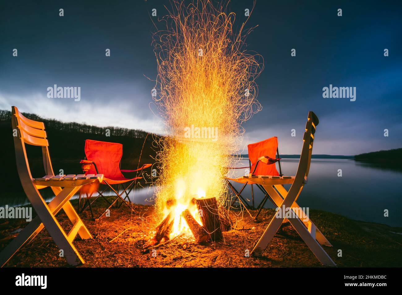 A breathtaking sparkling campfire with chairs around it on the ...
