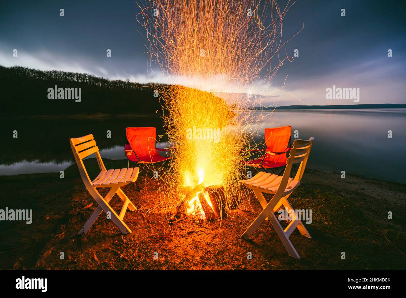 A breathtaking sparkling campfire with chairs around it on the ...