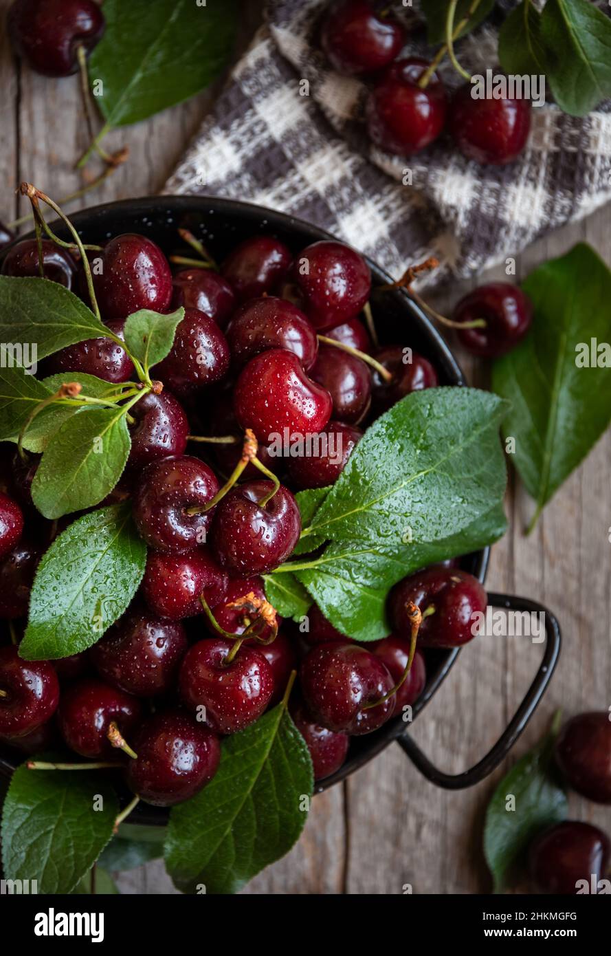 Fresh ripe dark cherries with green leaves Stock Photo - Alamy