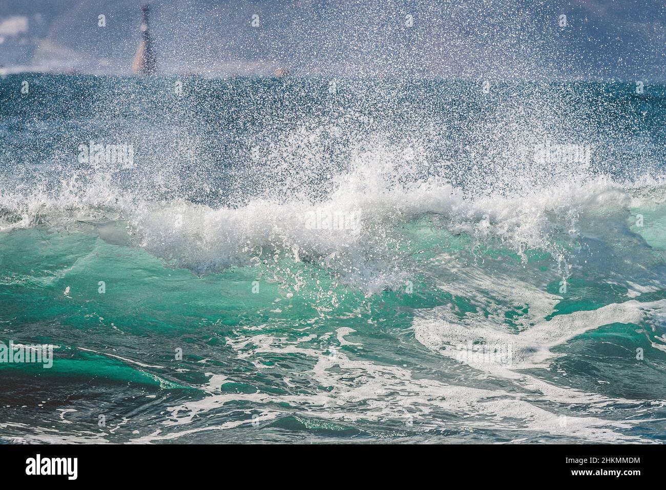 Wind whips up spray on an incoming wave Stock Photo - Alamy