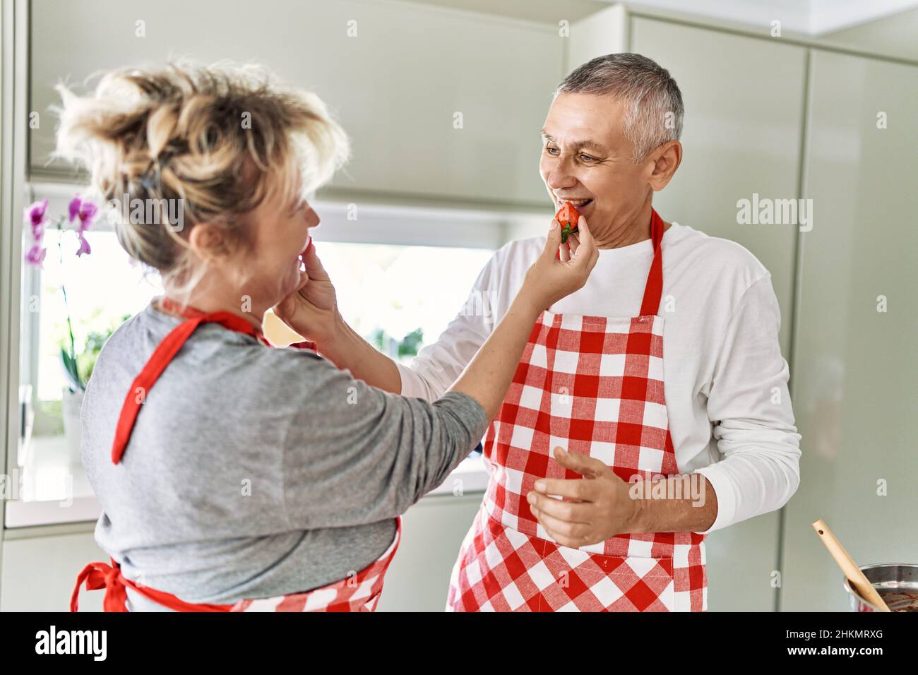Senior caucasian couple smiling happy giving strawberry to each other ...