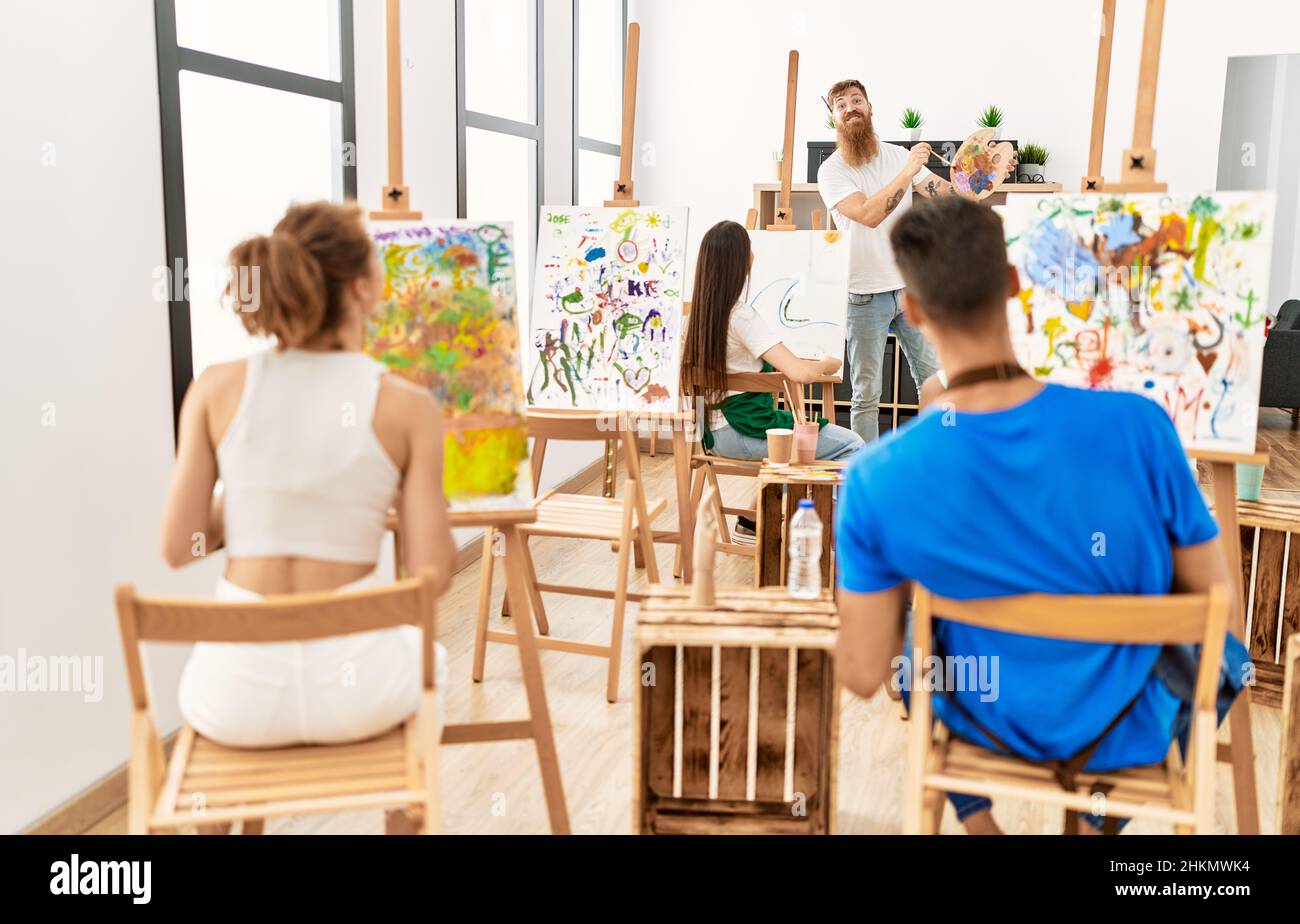 Group of people smiling happy drawing in paint class at art studio ...