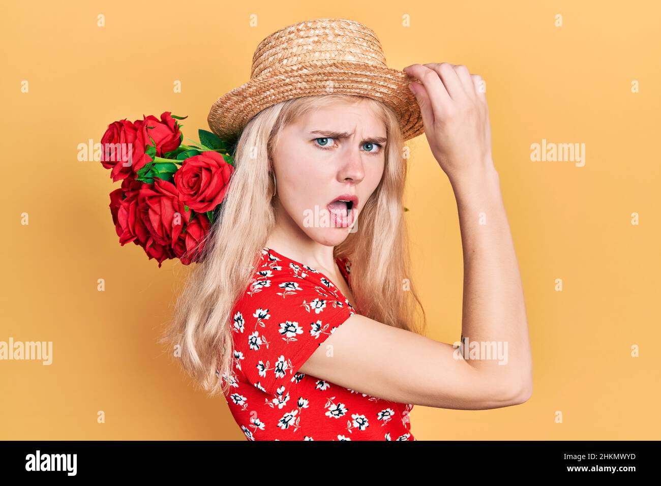 Beautiful caucasian woman with blond hair holding bouquet of red roses ...