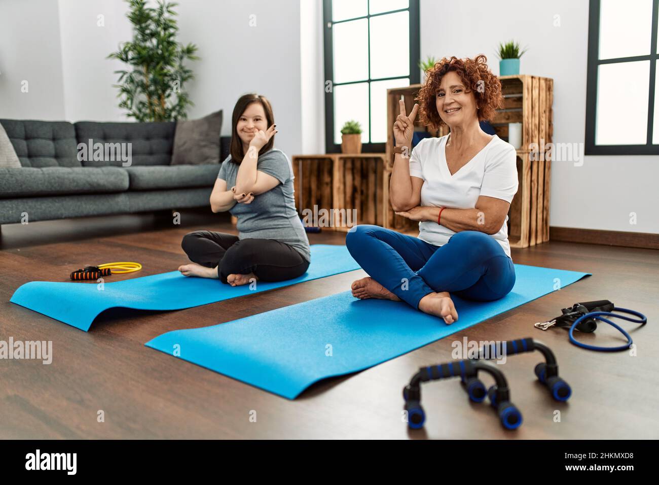 Family of mother and down syndrome daughter doing exercise at home ...