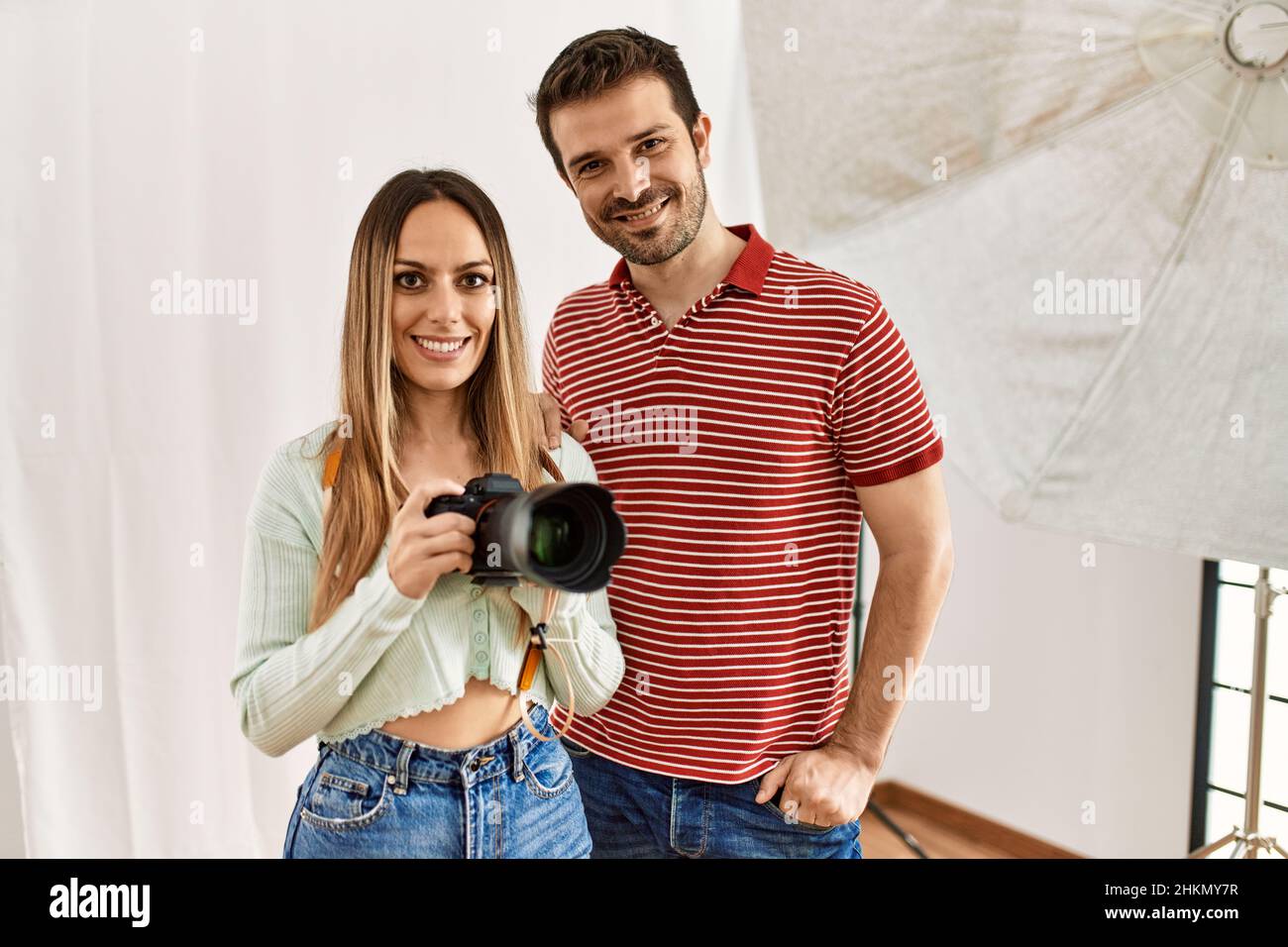 Professional photographer and model holding camera standing at ...