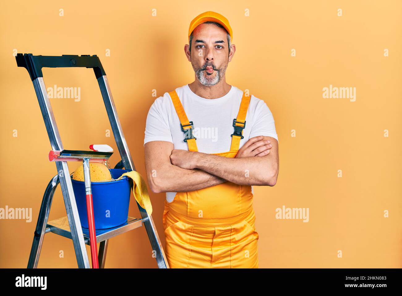 Handsome middle age man with grey hair window cleaner crossing arms ...