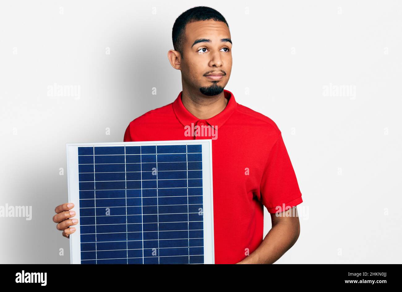 Young african american man holding photovoltaic solar panel smiling ...