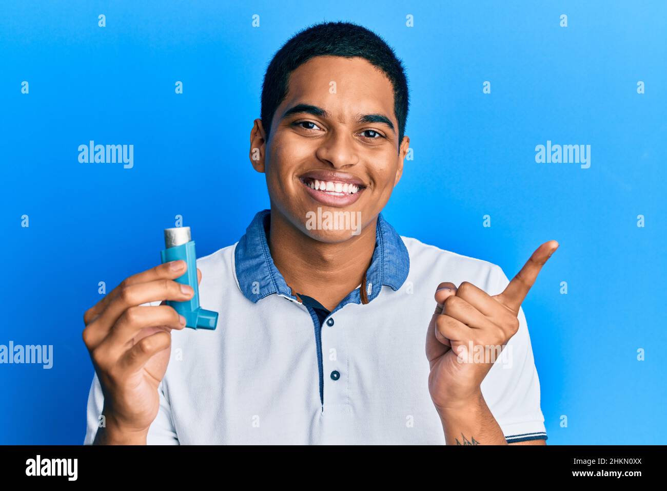 Young handsome hispanic man holding medical asthma inhaler smiling ...