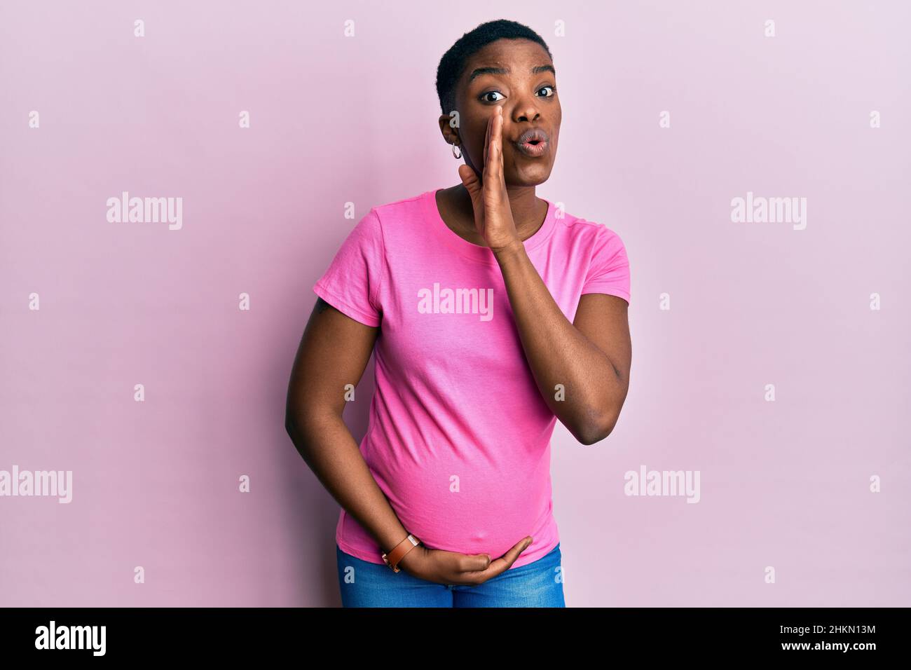Young african american woman expecting a baby, touching pregnant belly ...
