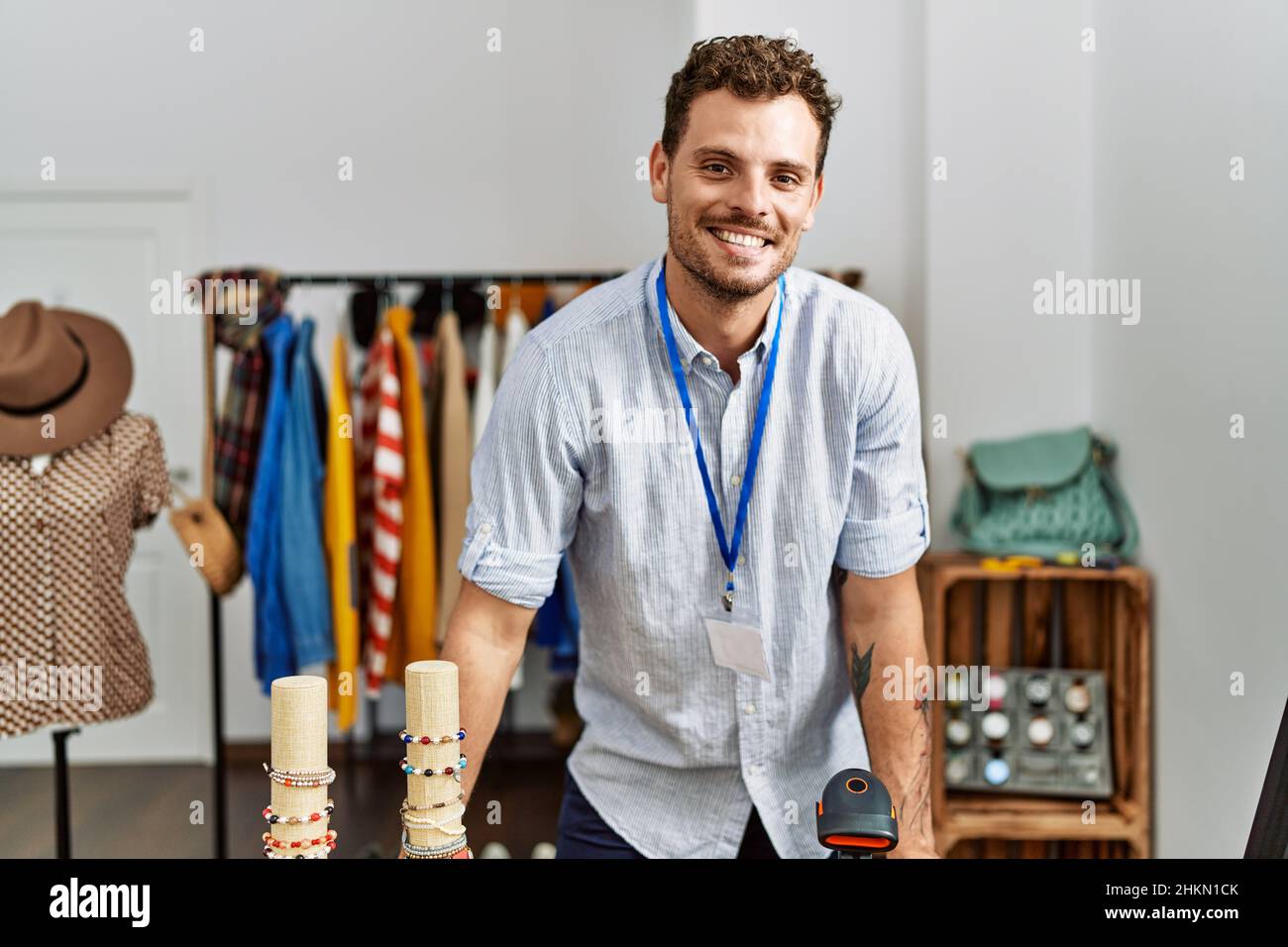 Young hispanic shopkeeper man smiling happy standing by counter at ...