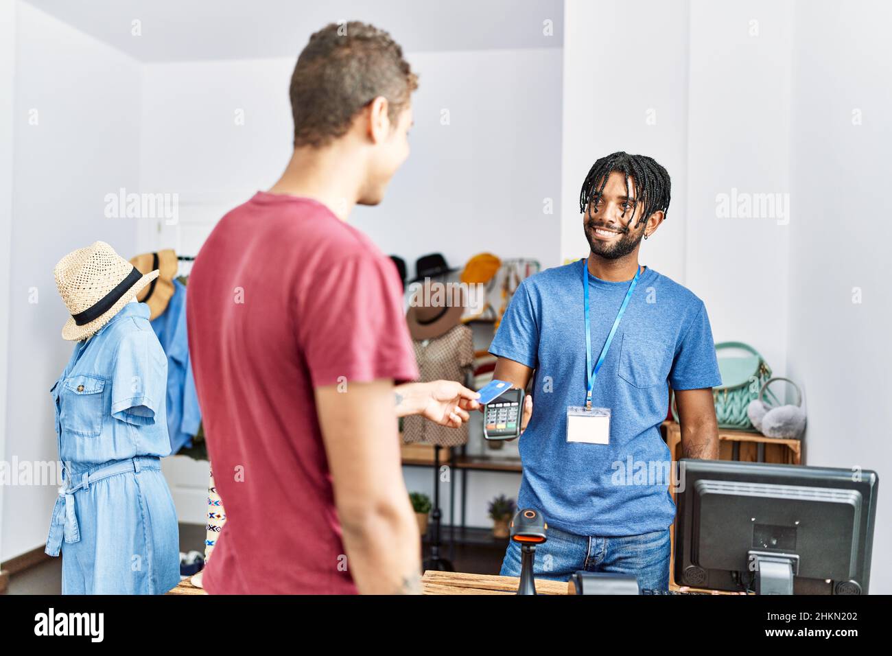 Two men shopkeeper and customer paying purchase using credit card and ...