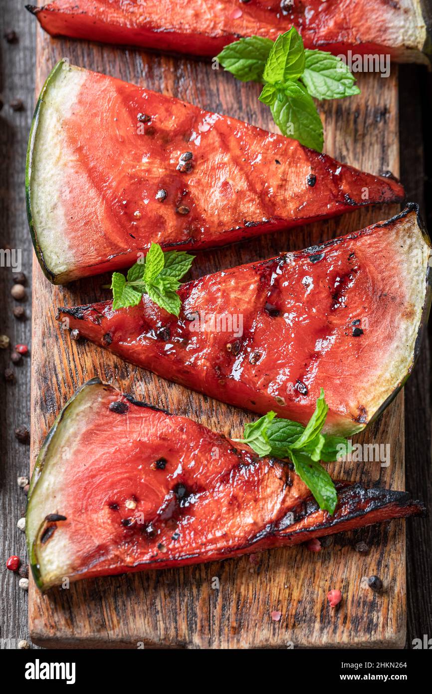 Sweet burned watermelon on grill grate with fire. Roasted watermelon on ...