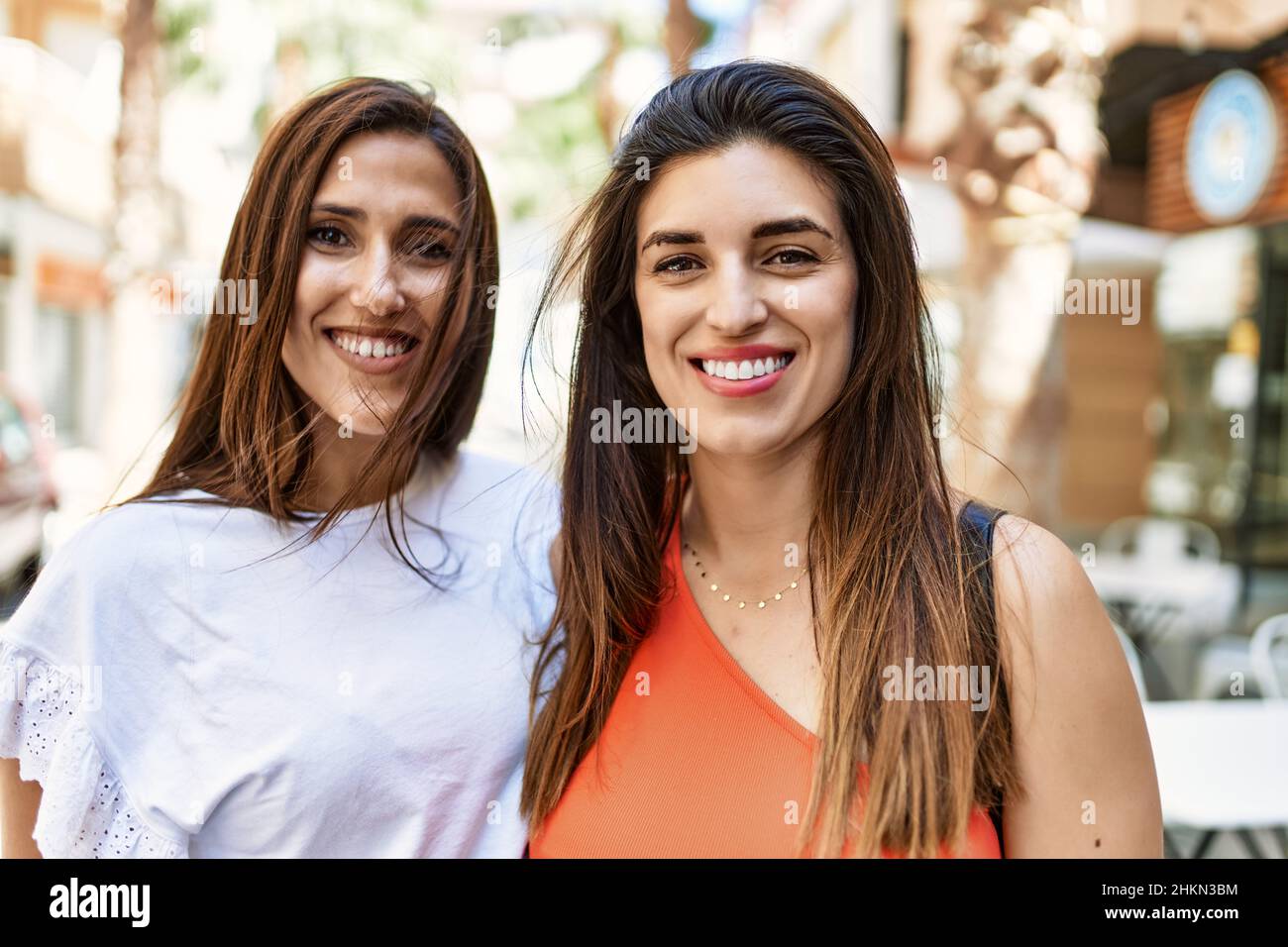 Two latin girls smiling happy and hugging at the city Stock Photo - Alamy