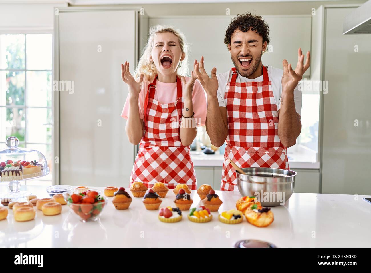 Couple of wife and husband cooking pastries at the kitchen celebrating ...