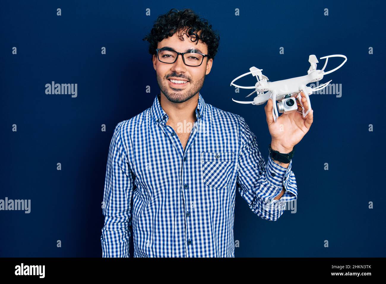 Young hispanic man holding drone looking positive and happy standing ...
