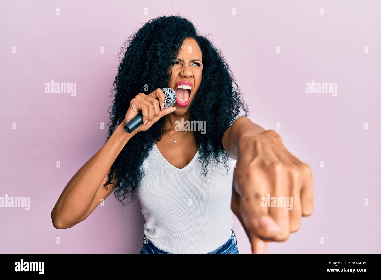 Middle age african american woman singing song using microphone ...