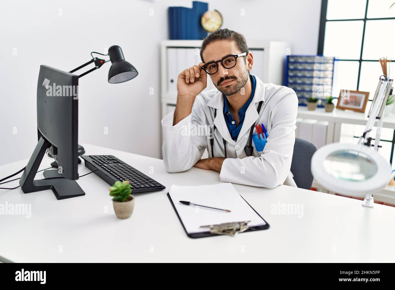 Handsome hispanic man working as doctor at hospital clinic Stock Photo ...