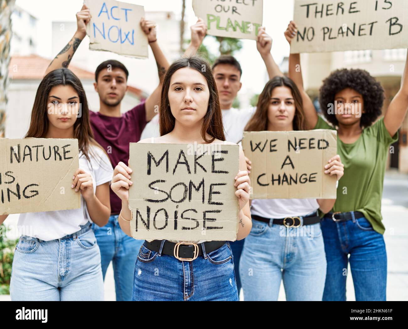 Group of young activists people holding protest banner protesting at ...