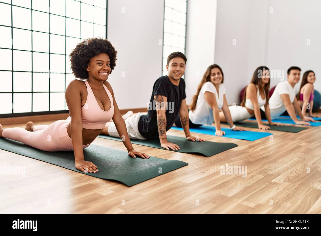 Group of young sporty people smiling happy training yoga at sport ...