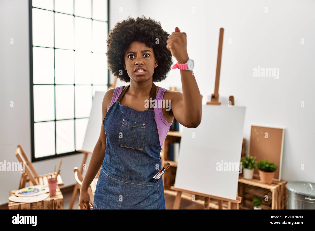 Young african american woman with afro hair at art studio angry and mad ...