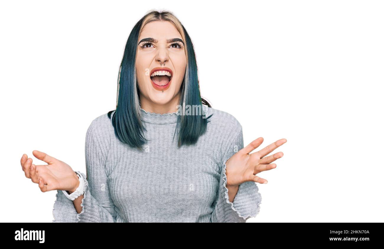 Young modern girl wearing casual sweater crazy and mad shouting and ...