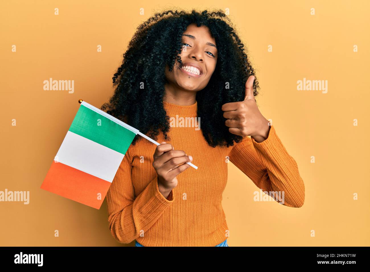 African american woman with afro hair holding ireland flag smiling ...