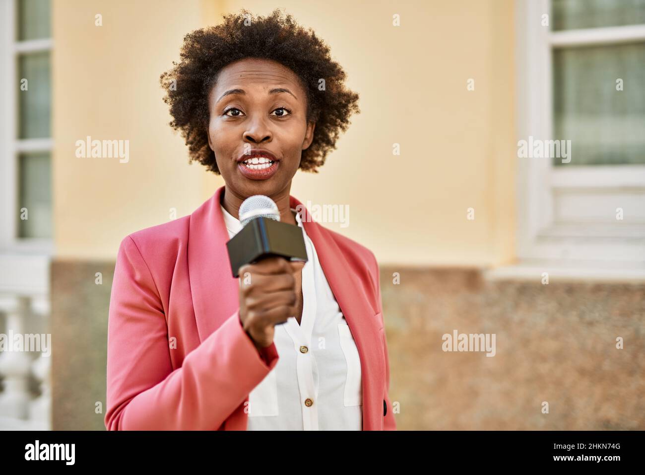 Young african american woman journalist holding reporter microphone ...