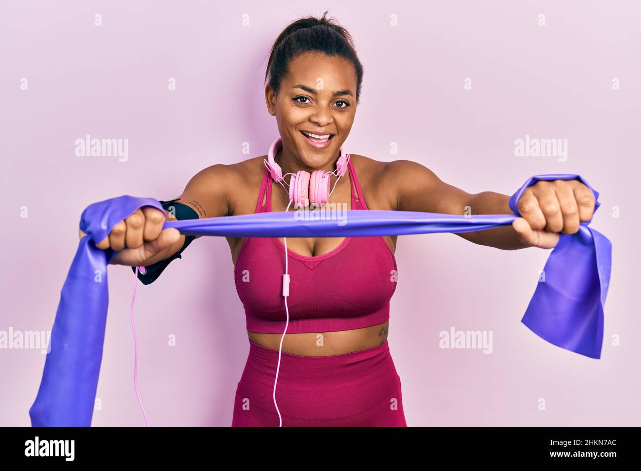 Young african american girl training arm resistance with elastic arm ...