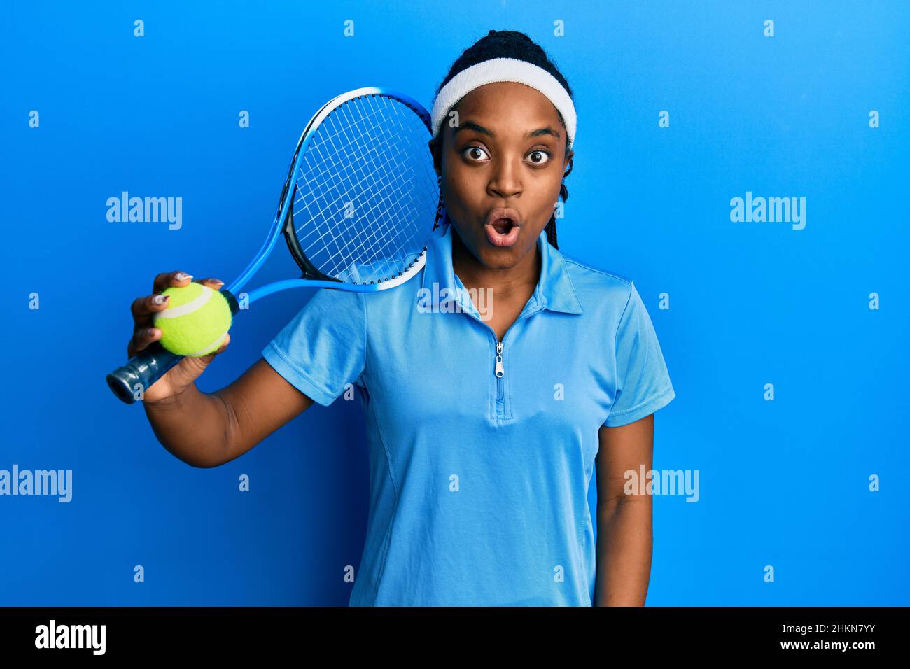African american woman with braided hair playing tennis holding racket ...